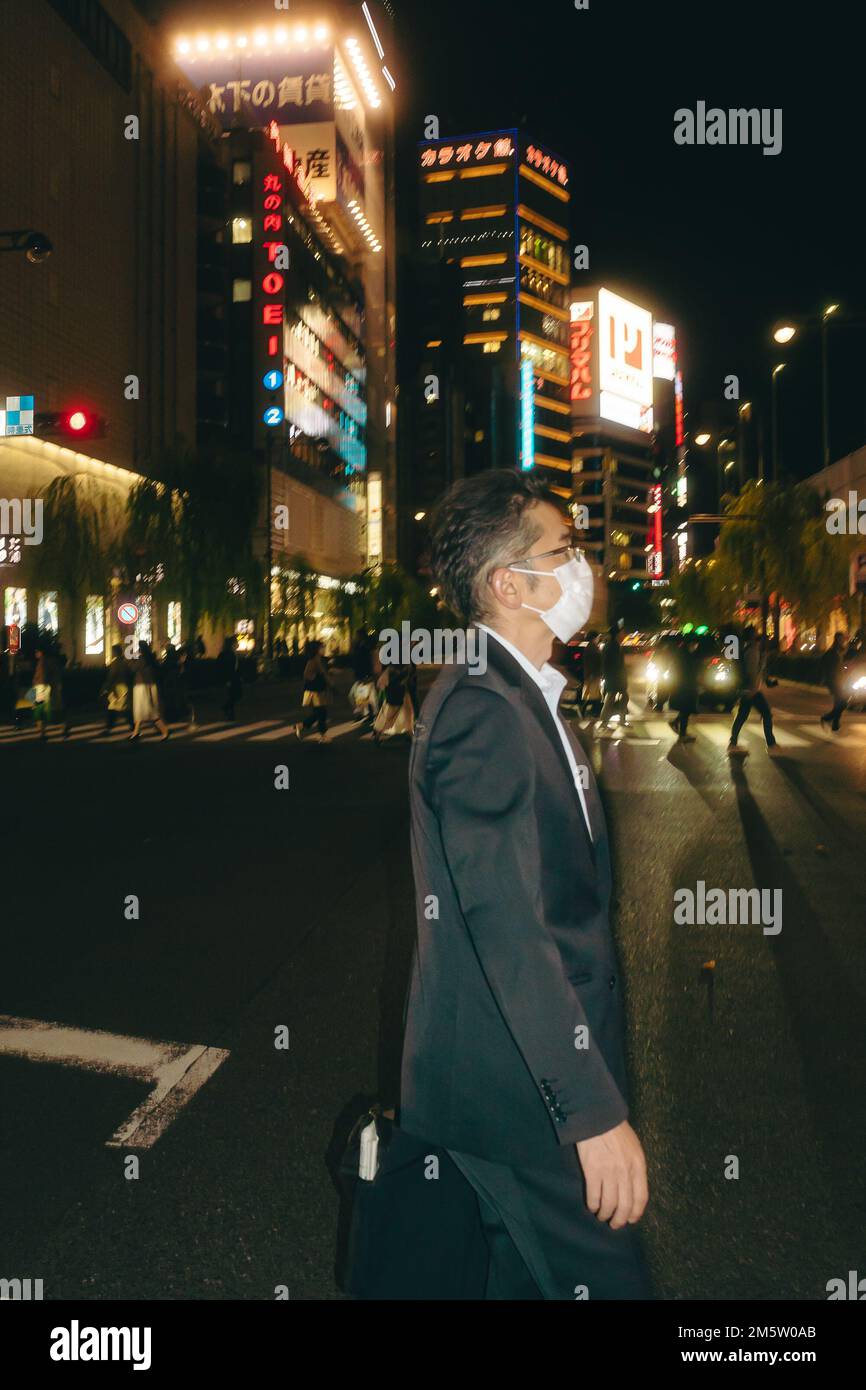 man in face mask crossing the streets of Ginza at night Stock Photo - Alamy