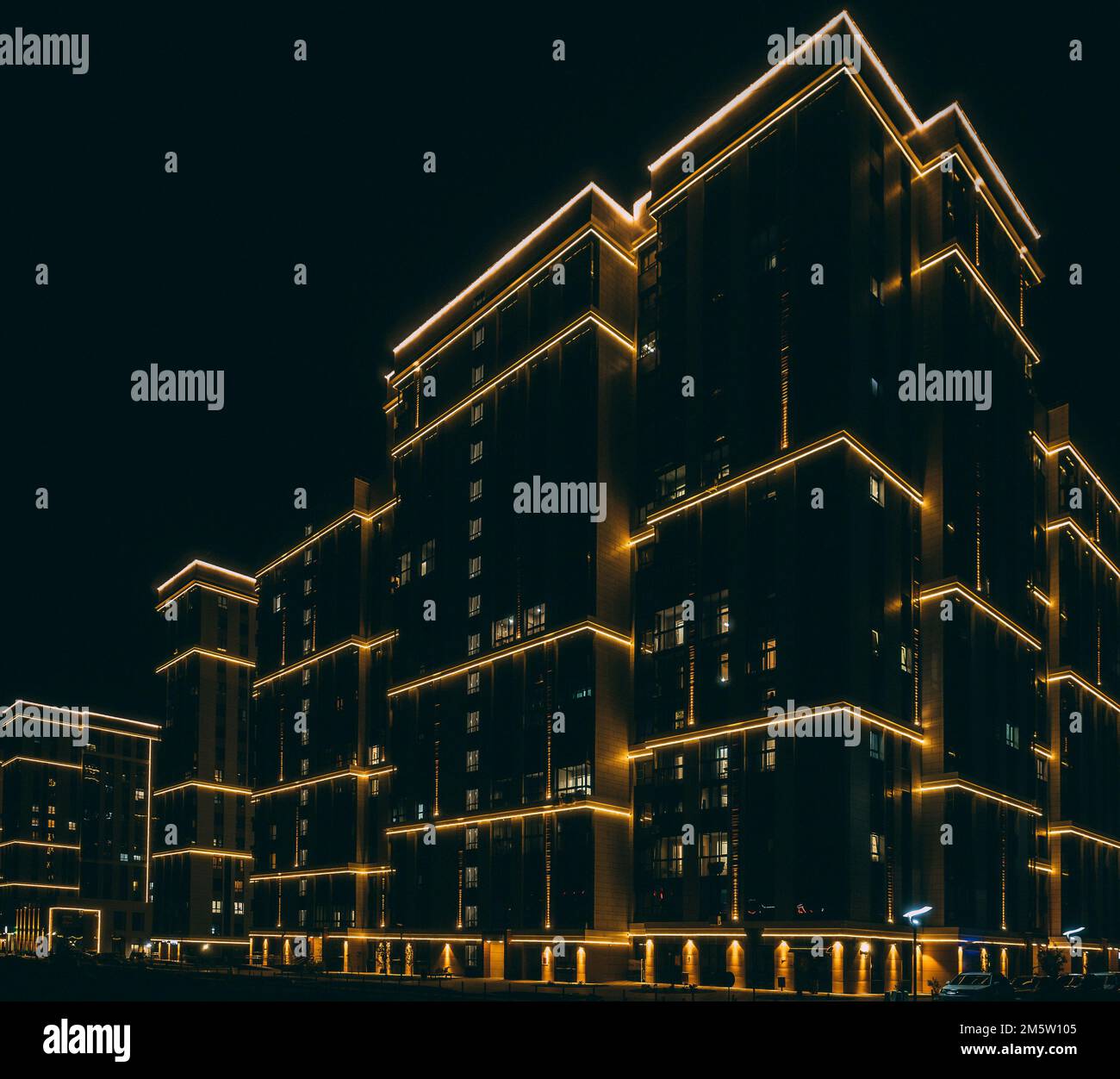 Night city. Modern residential multi-storey house with illumination ...