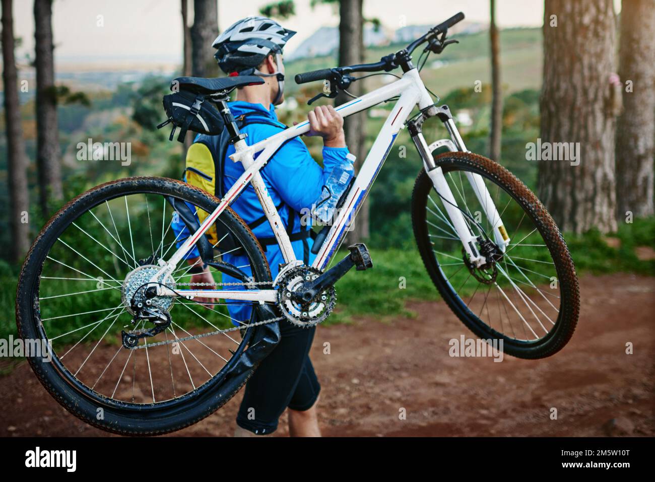 Taking his bike out for a spin. a male cyclist walking along a trail ...