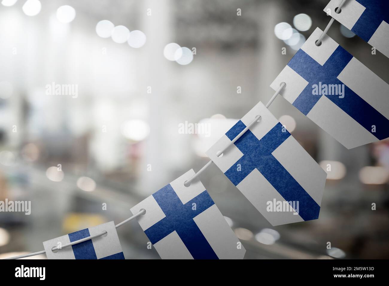 A garland of Finland national flags on an abstract blurred background ...