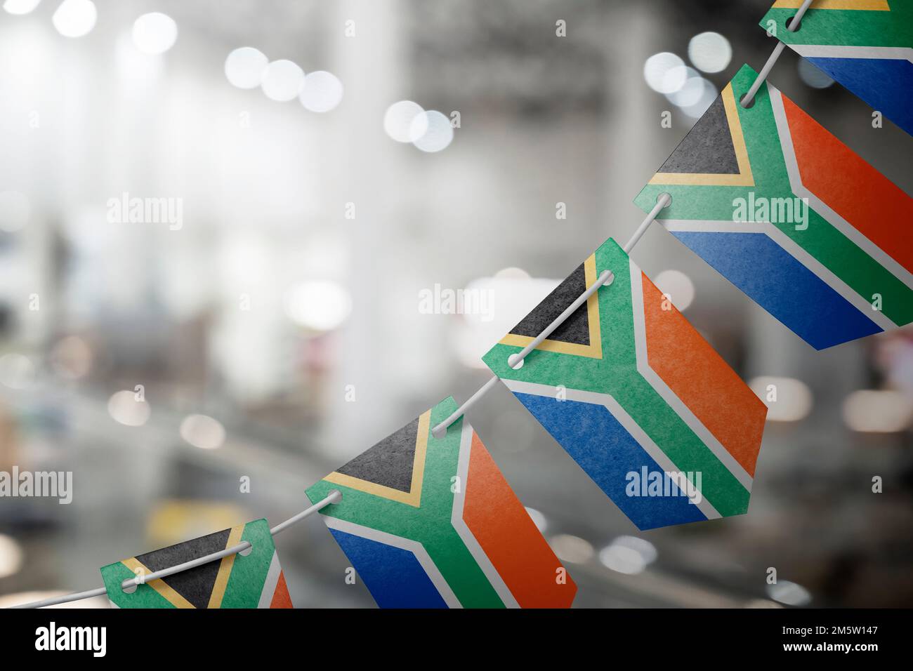 A garland of South Africa national flags on an abstract blurred ...