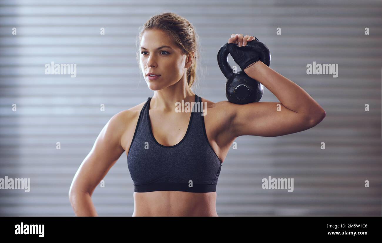 Fit is the way to go. a young woman working out with kettlebells Stock ...