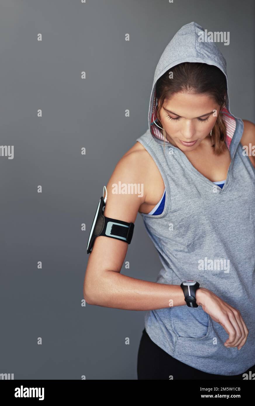 Trying to beat her best. a sporty young woman checking the time on her ...