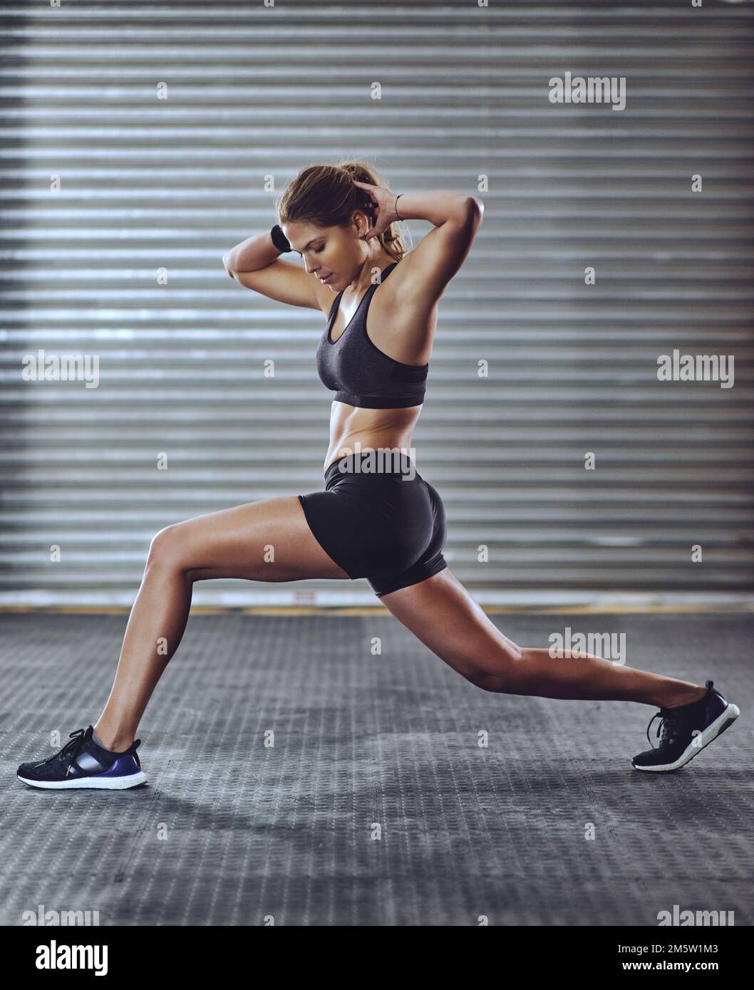 Really working those leg muscles. a young woman working out at the gym ...