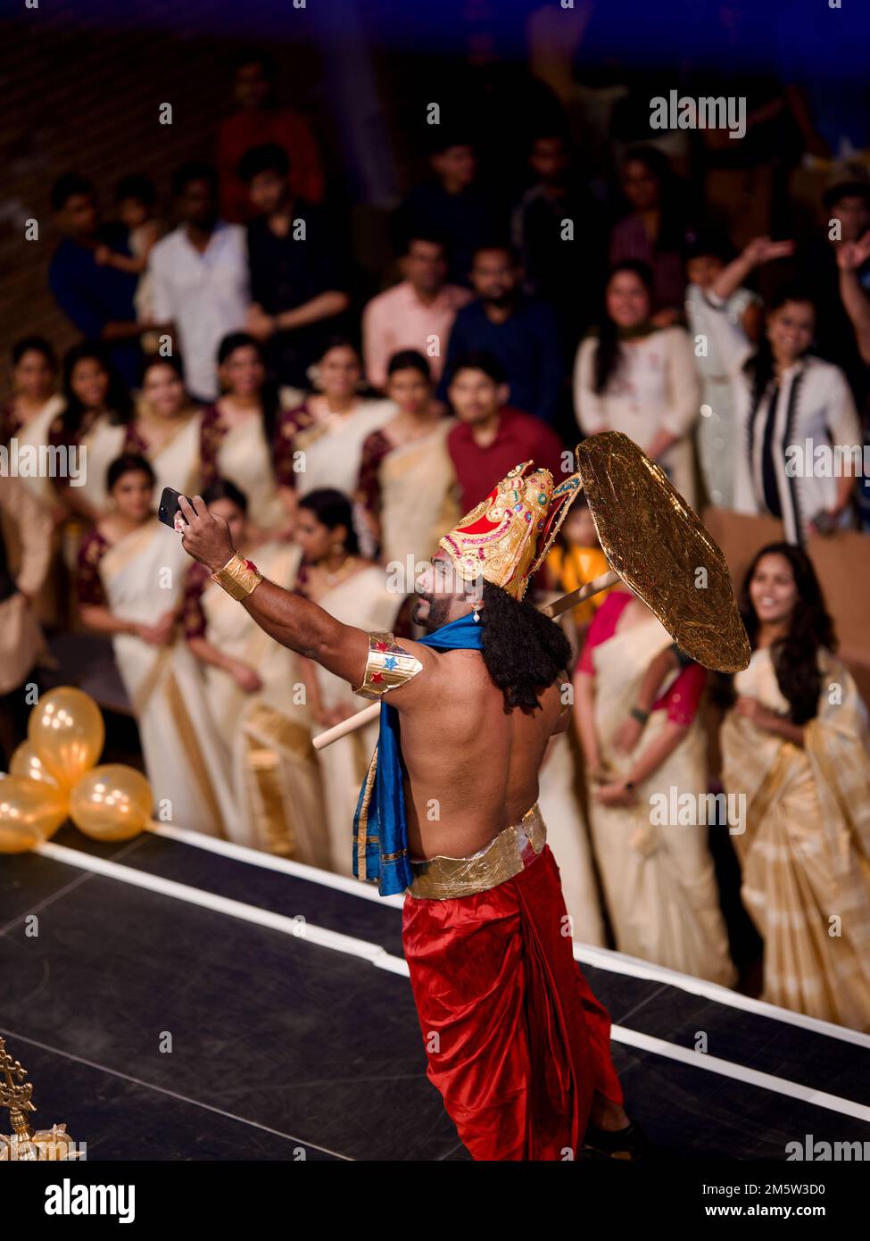 A man in the role of Onapottan with an umbrella on a stage during the ...