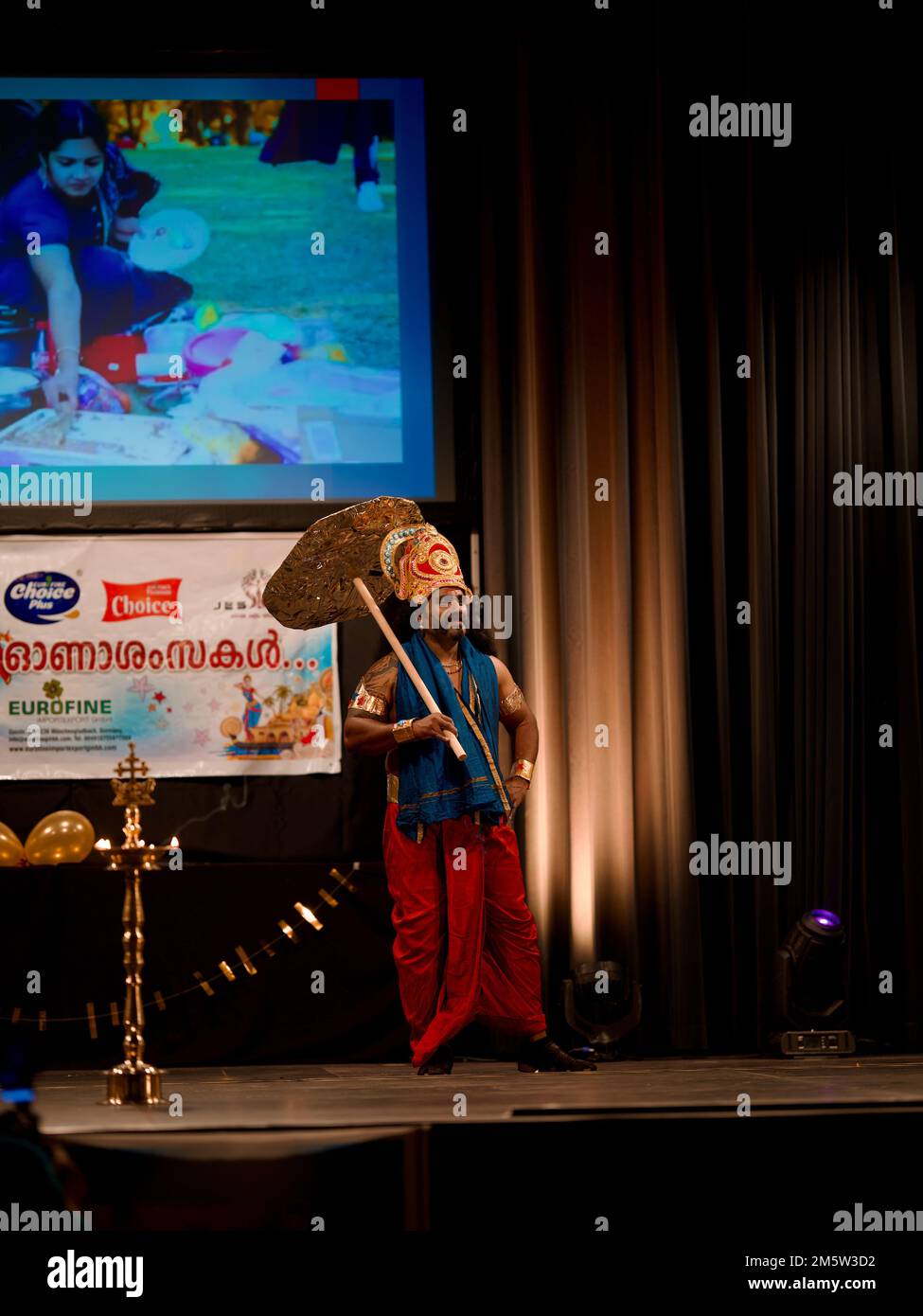A man in the role of Onapottan with an umbrella on a stage during the ...