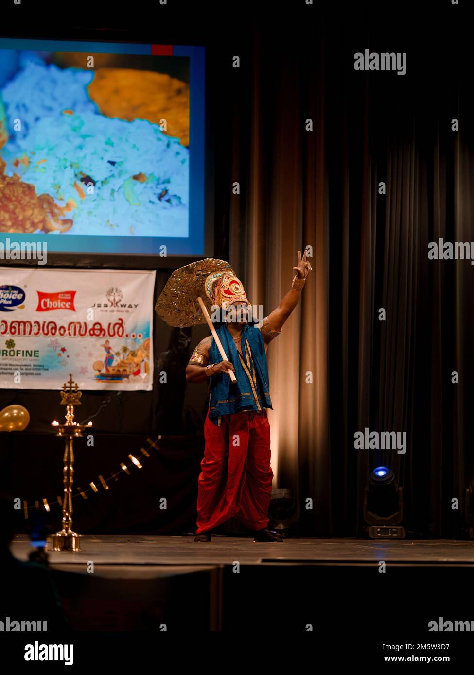 A man in the role of Onapottan with an umbrella on a stage during the ...