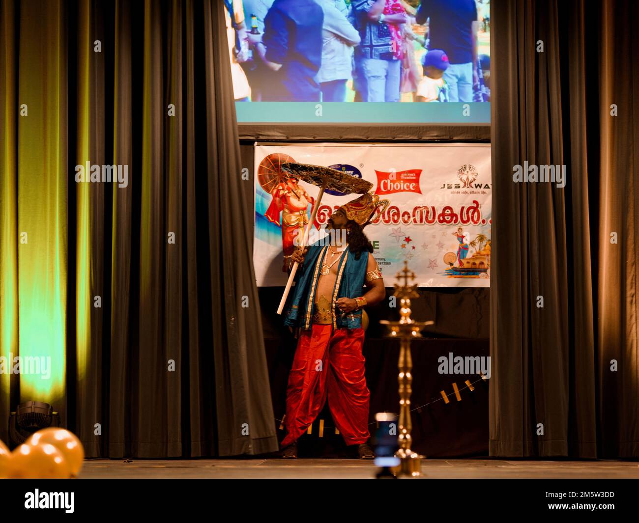A man in the role of Onapottan with an umbrella on a stage during the ...