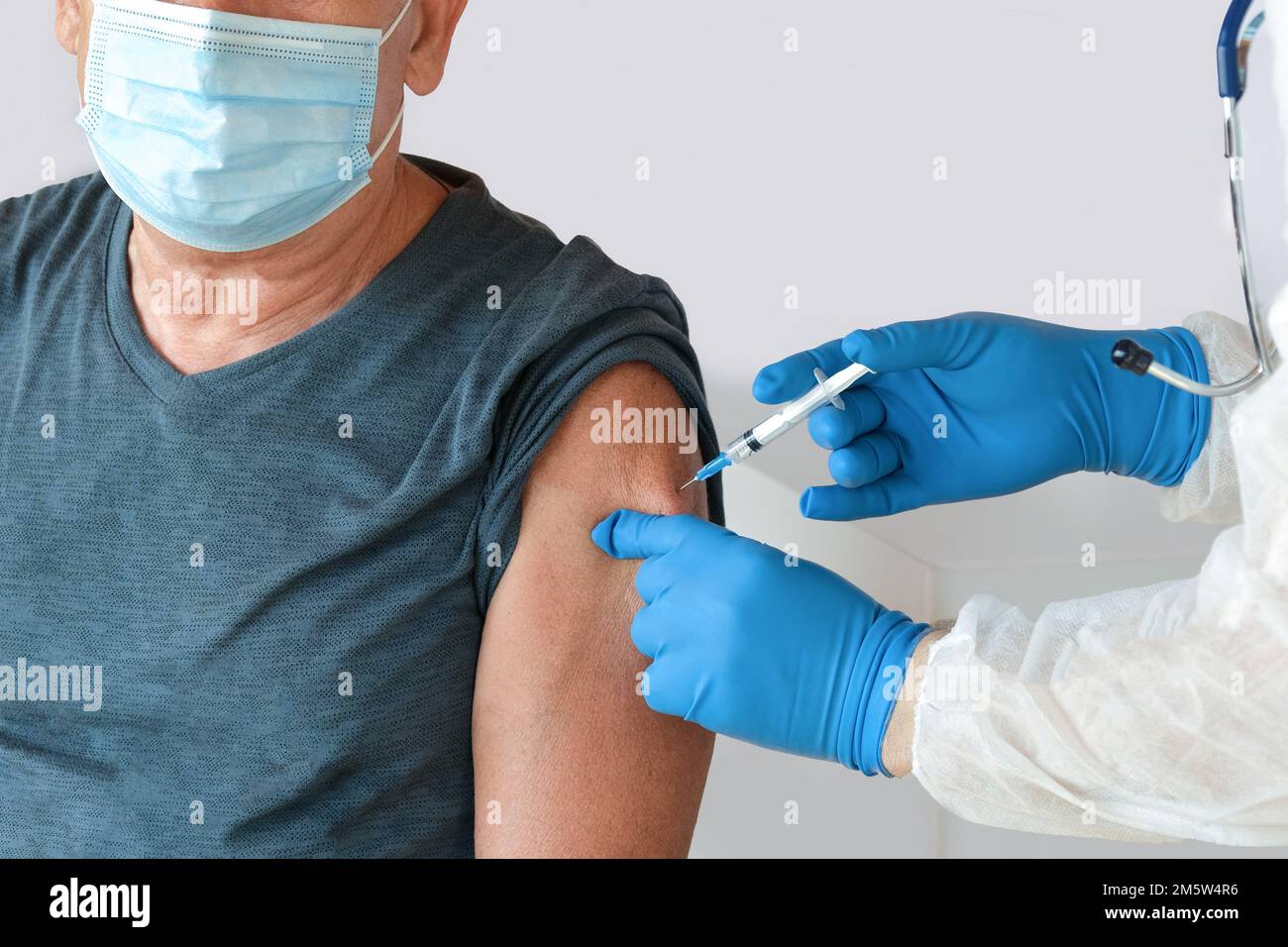 Doctor Vaccinating Senior Man In Clinic. Older People Vaccination ...