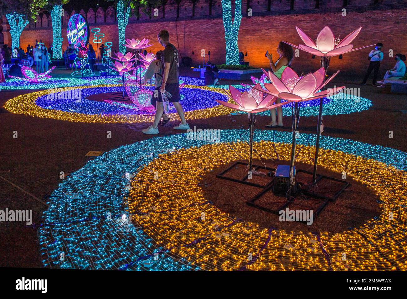Foreign tourists walk past light illuminations installed during New ...