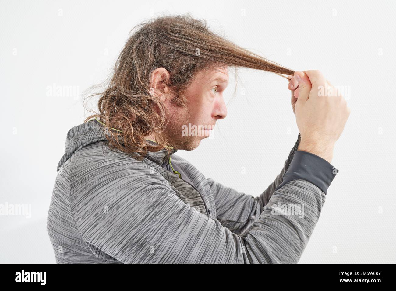 Man suprised about his long hair Stock Photo - Alamy