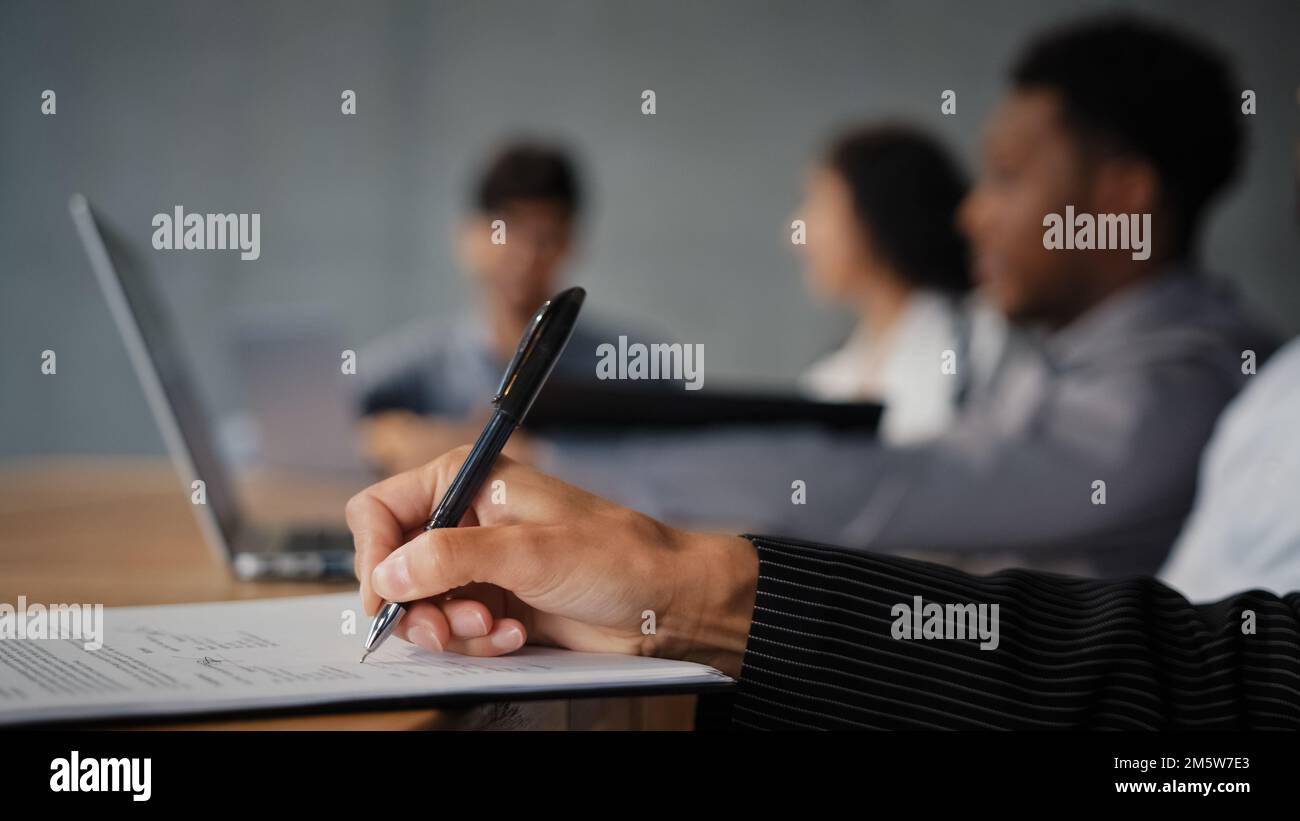 Close-up female hand writing notes on paper signing document contract ...
