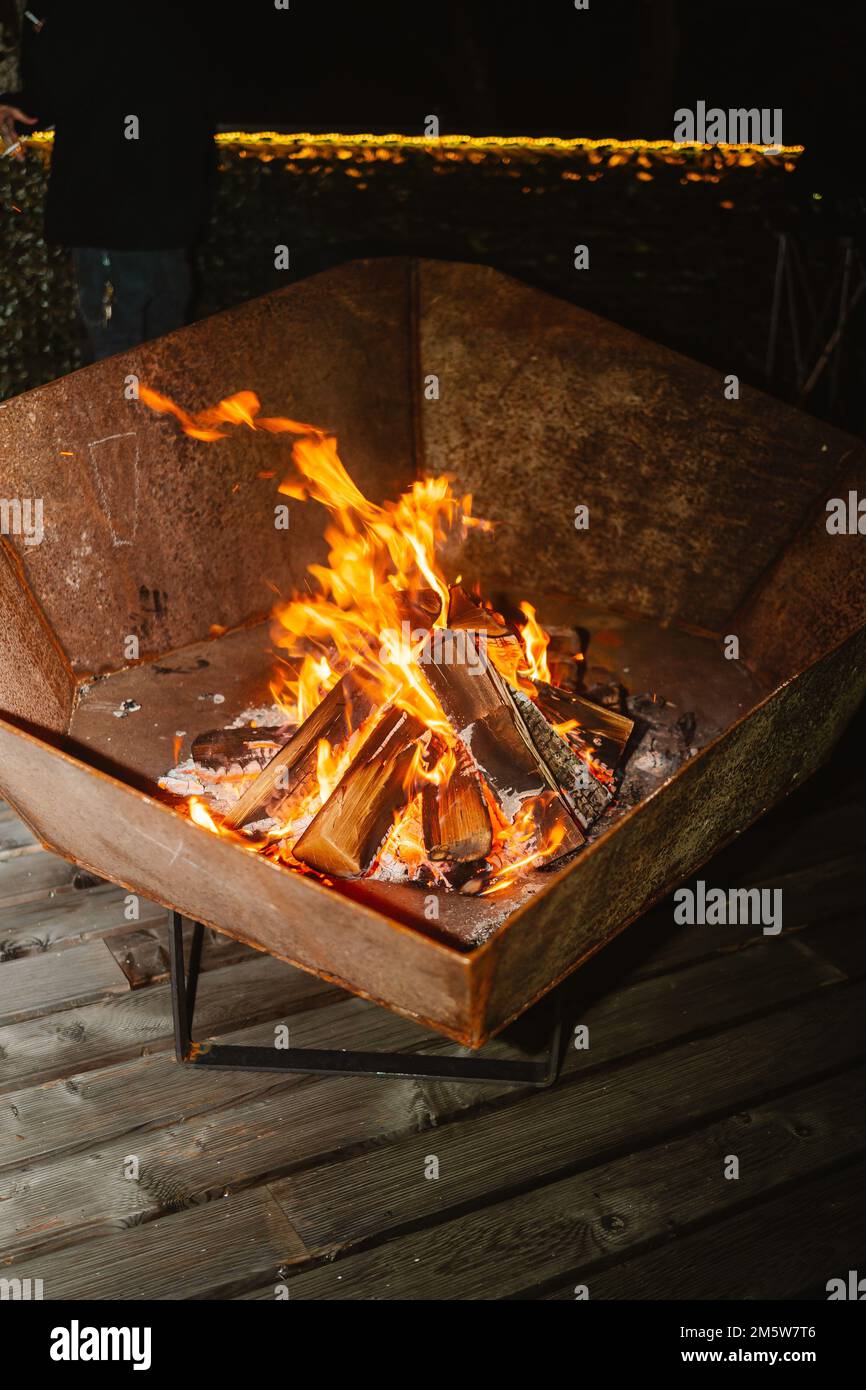 A vertical shot of a small bonfire burning in a metal container Stock ...