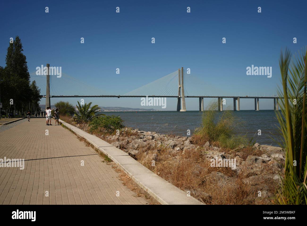 Passage way at the seashore with a distant bridge Stock Photo - Alamy