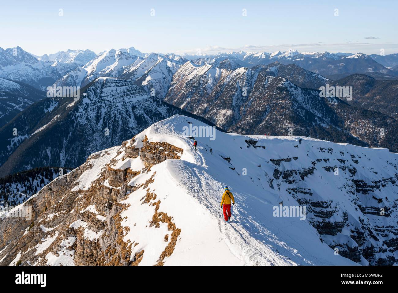 Two ski tourers at the summit of Schafreuter, view of snowy mountain ...