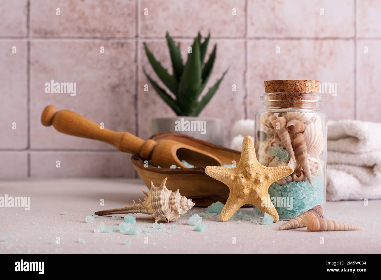 Blue sea salt in wooden bowl with shells and white towels for relax ...
