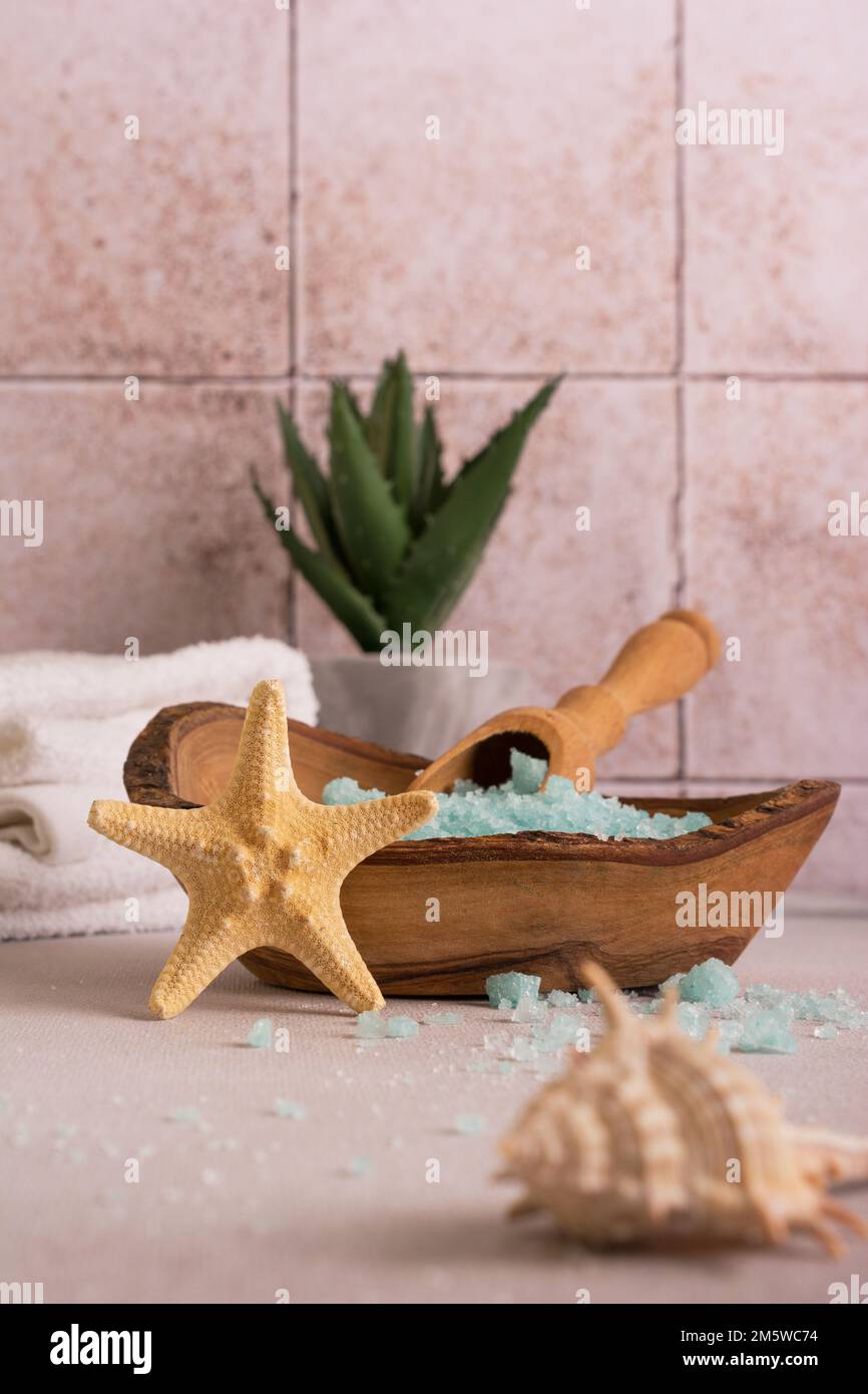 Blue sea salt in wooden bowl with shells and white towels for relax ...