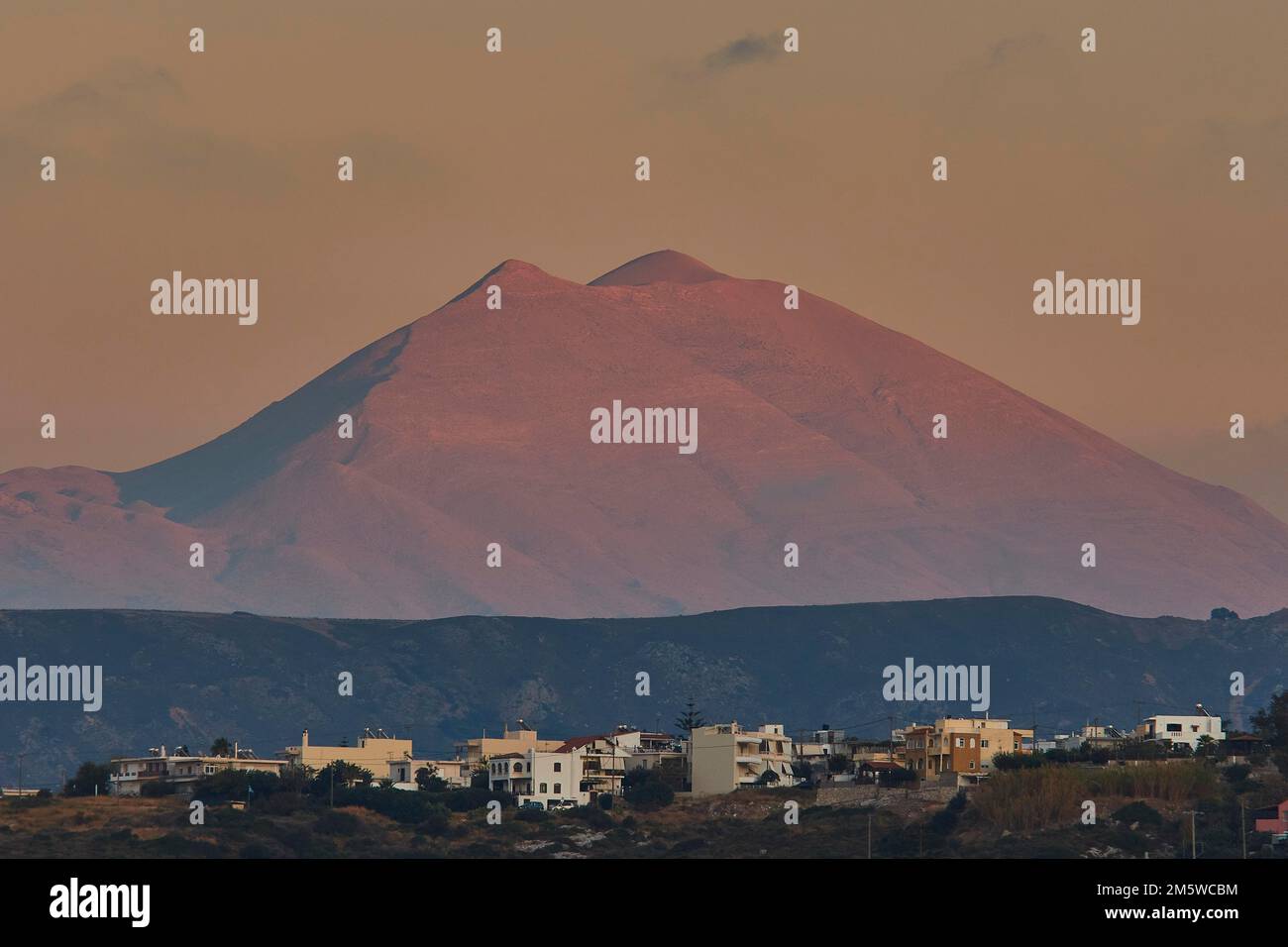 Red evening light, houses on hill, Ida massif, double peak, close ...