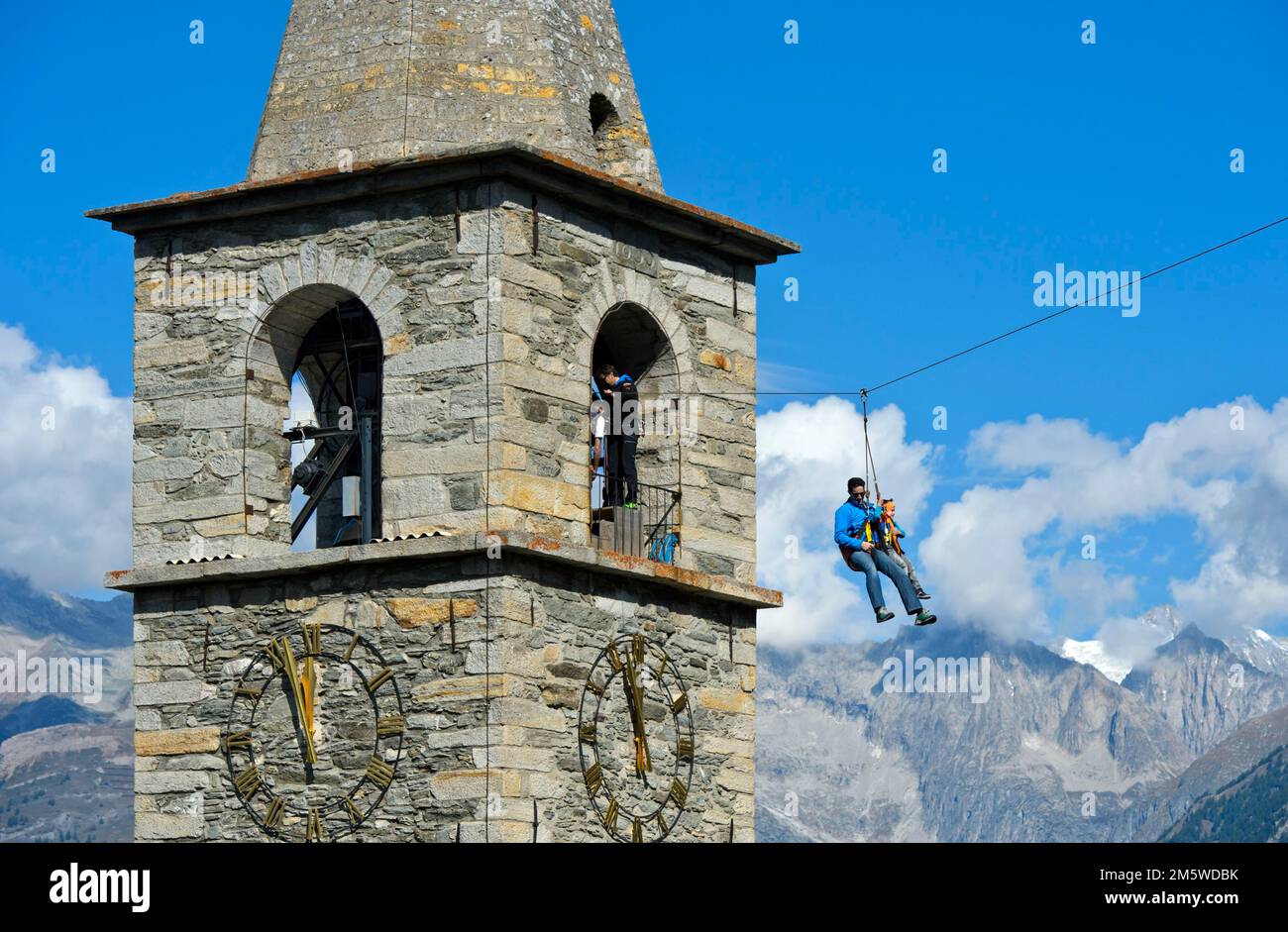 Father and daughter hang from the rope of a zip wire and glide from the ...