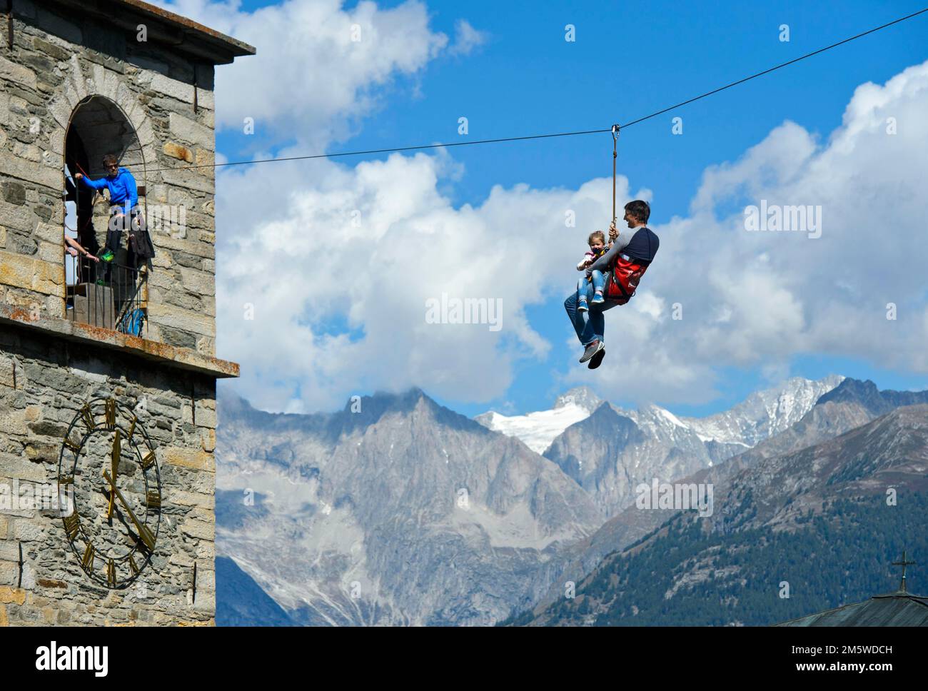 Father and his daughter glide down a zip wire from the church tower to ...