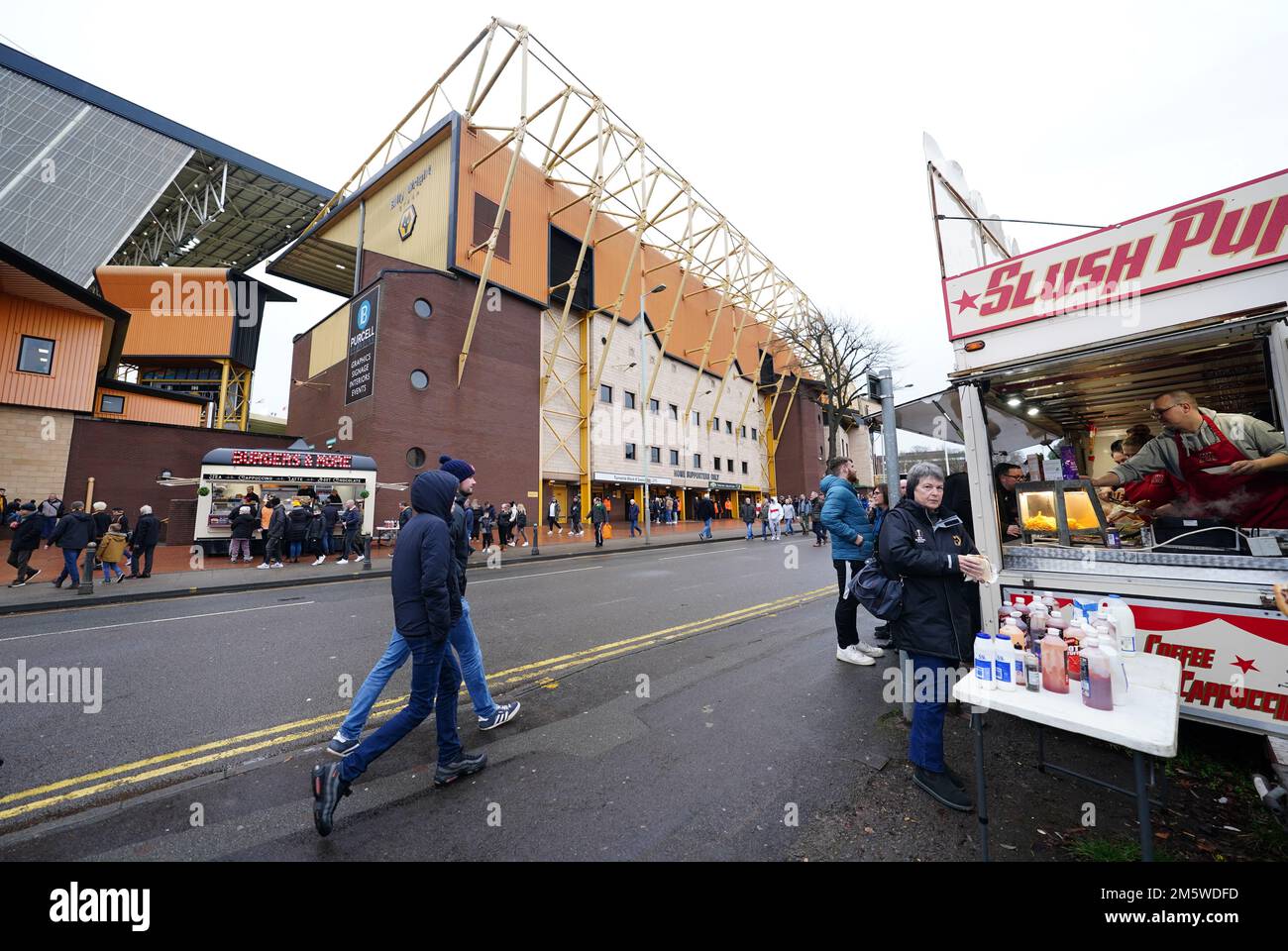 Fans walk by a fast food vendor before the Premier League match at ...
