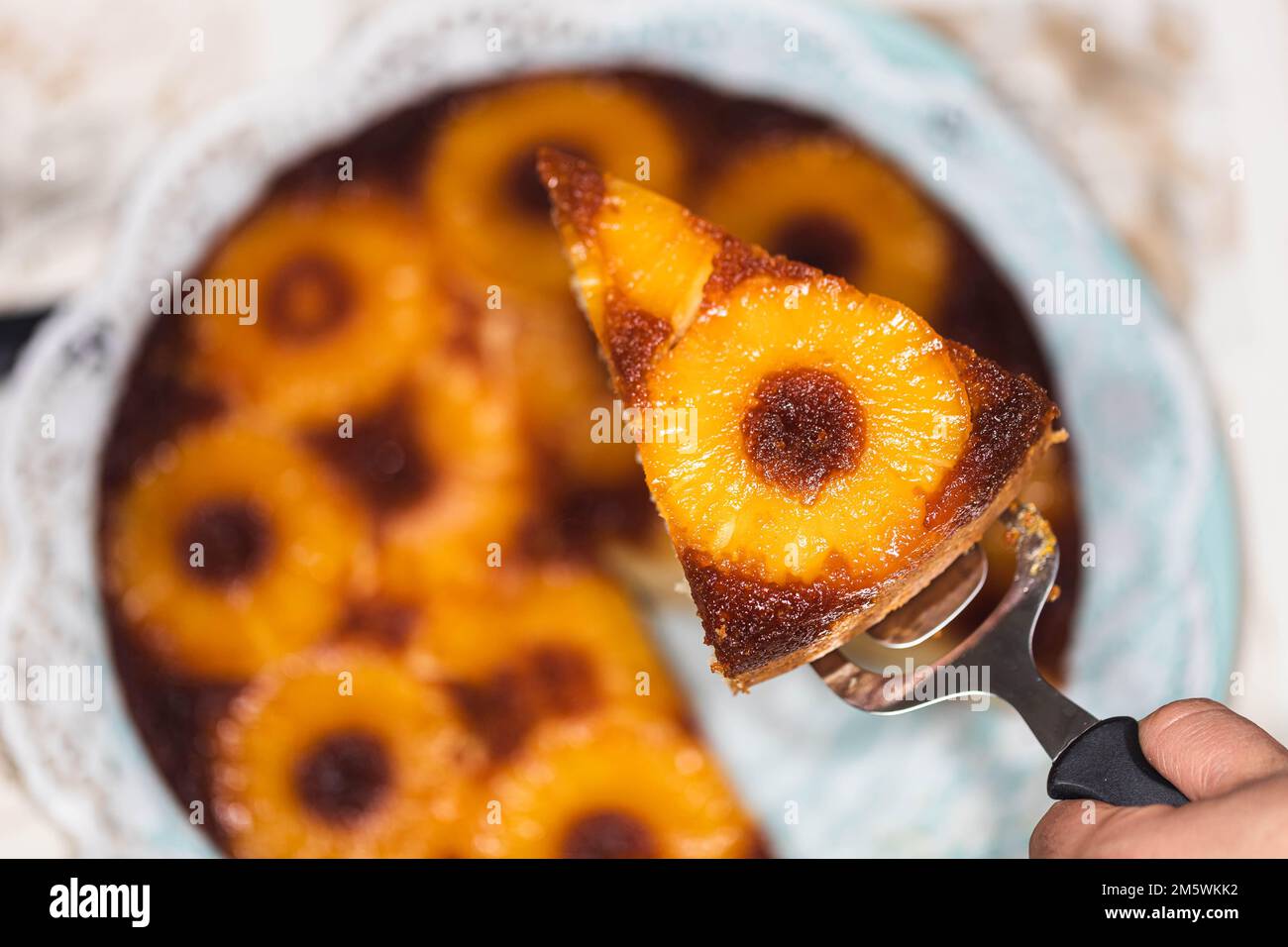 A tantalizing slice of pineapple cake being lifted, with a blurred ...