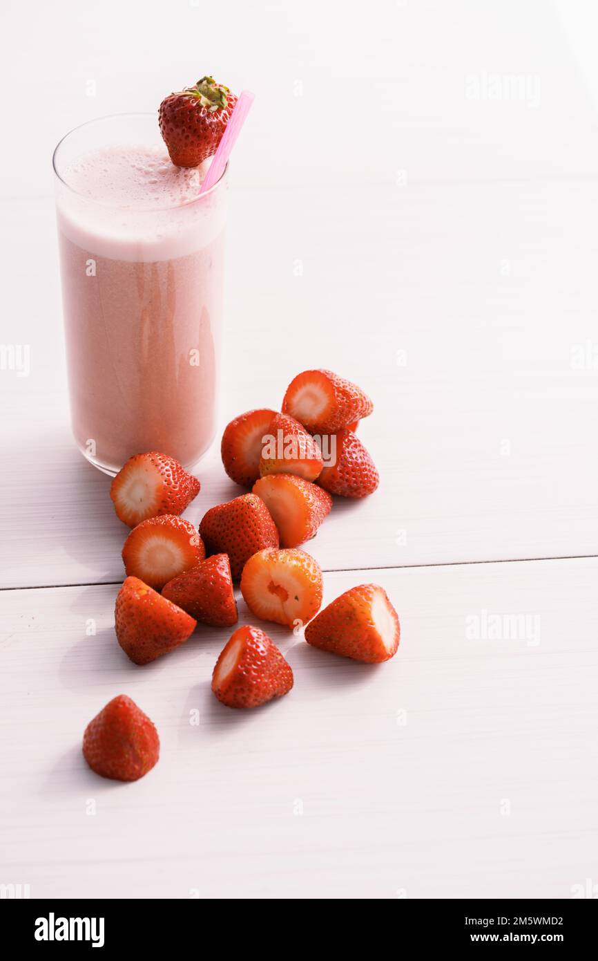 A vertical closeup of a fresh strawberry Milk smoothie in a cup with a ...