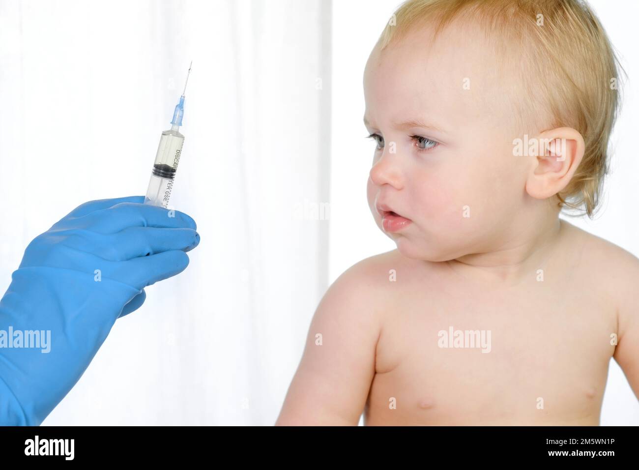 Doctor vaccinating baby in clinic. Little baby get an injection ...