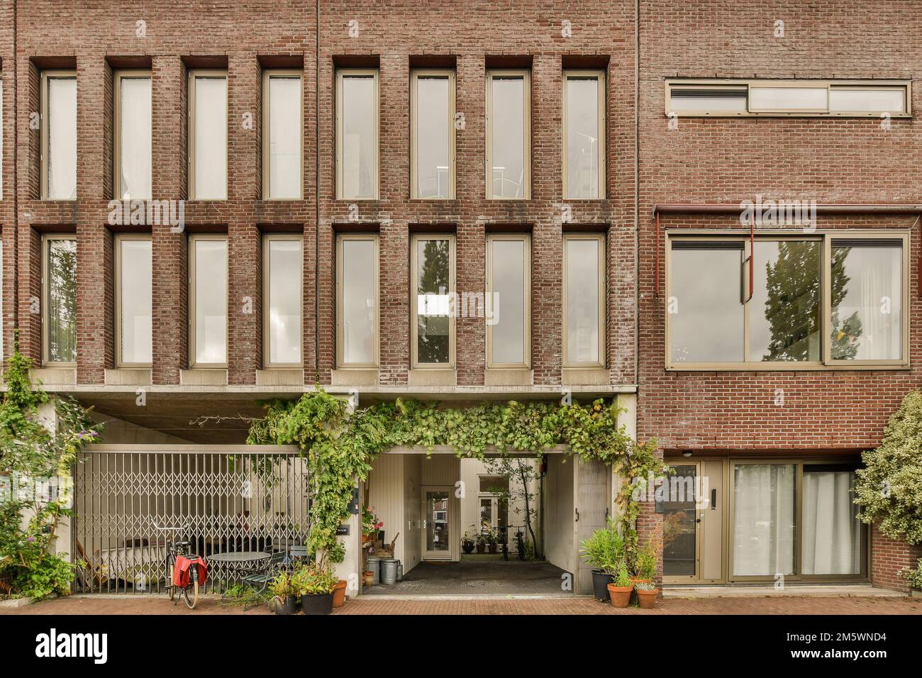 an apartment building with plants growing on the front and two people ...