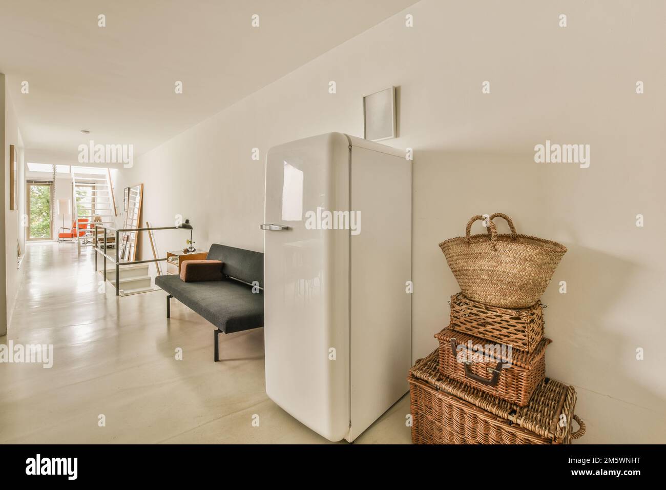a living room with a white refrigerator and some wickers on the floor ...