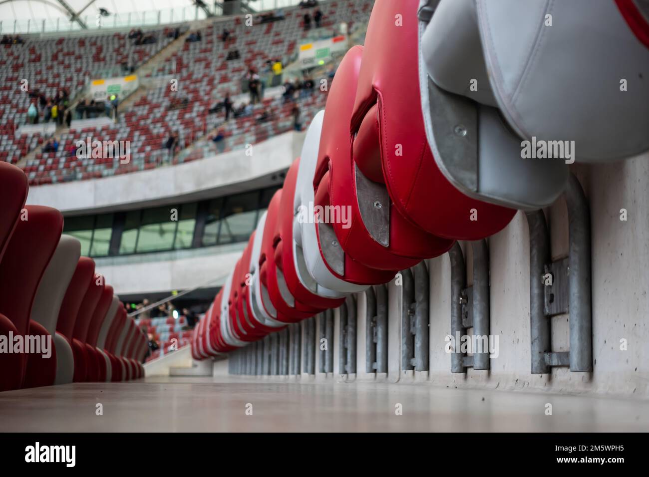Rows of empty white and red chairs in a football stadium. Anticipation ...