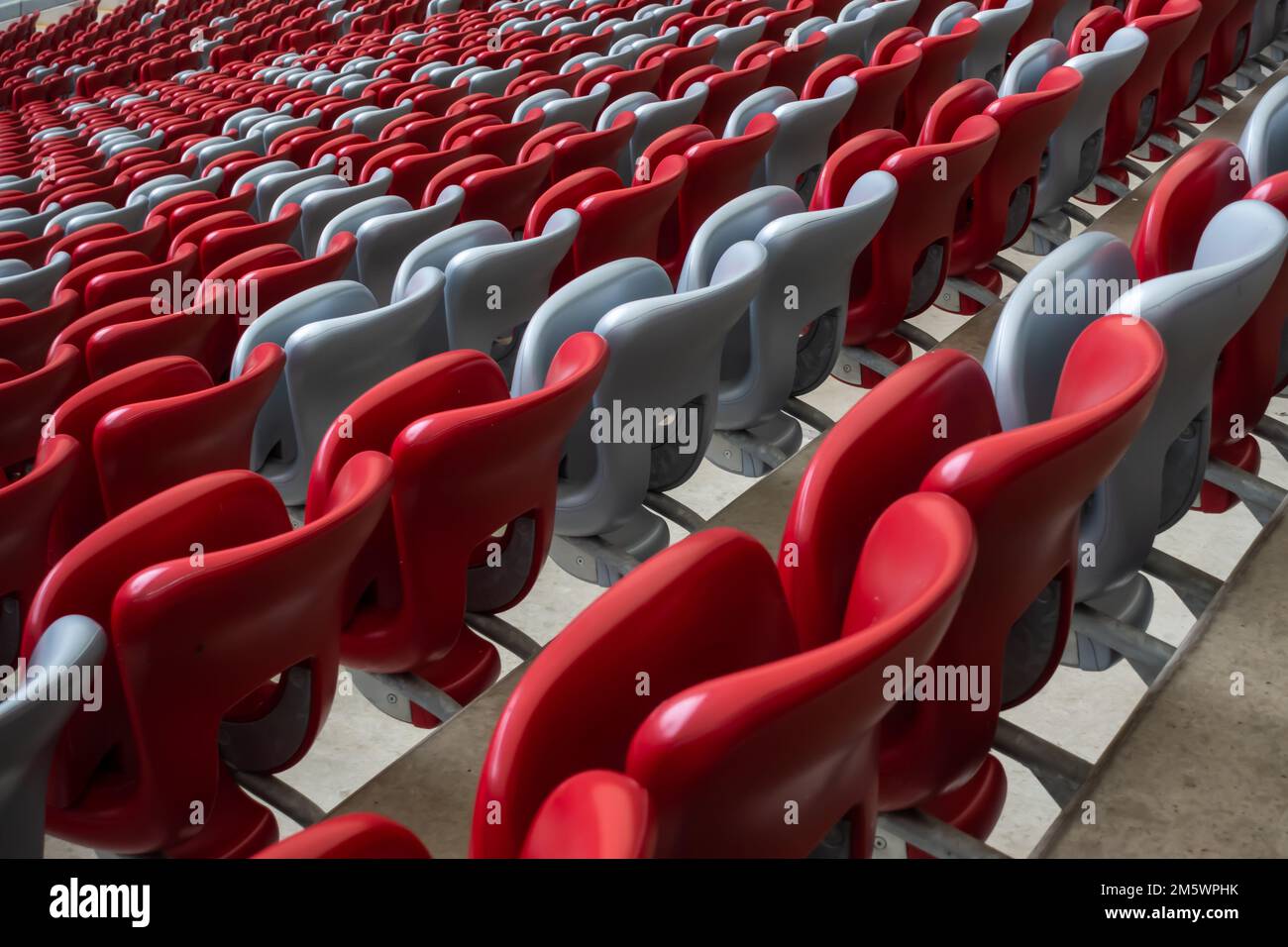 Rows of empty white and red chairs in a football stadium. Anticipation ...