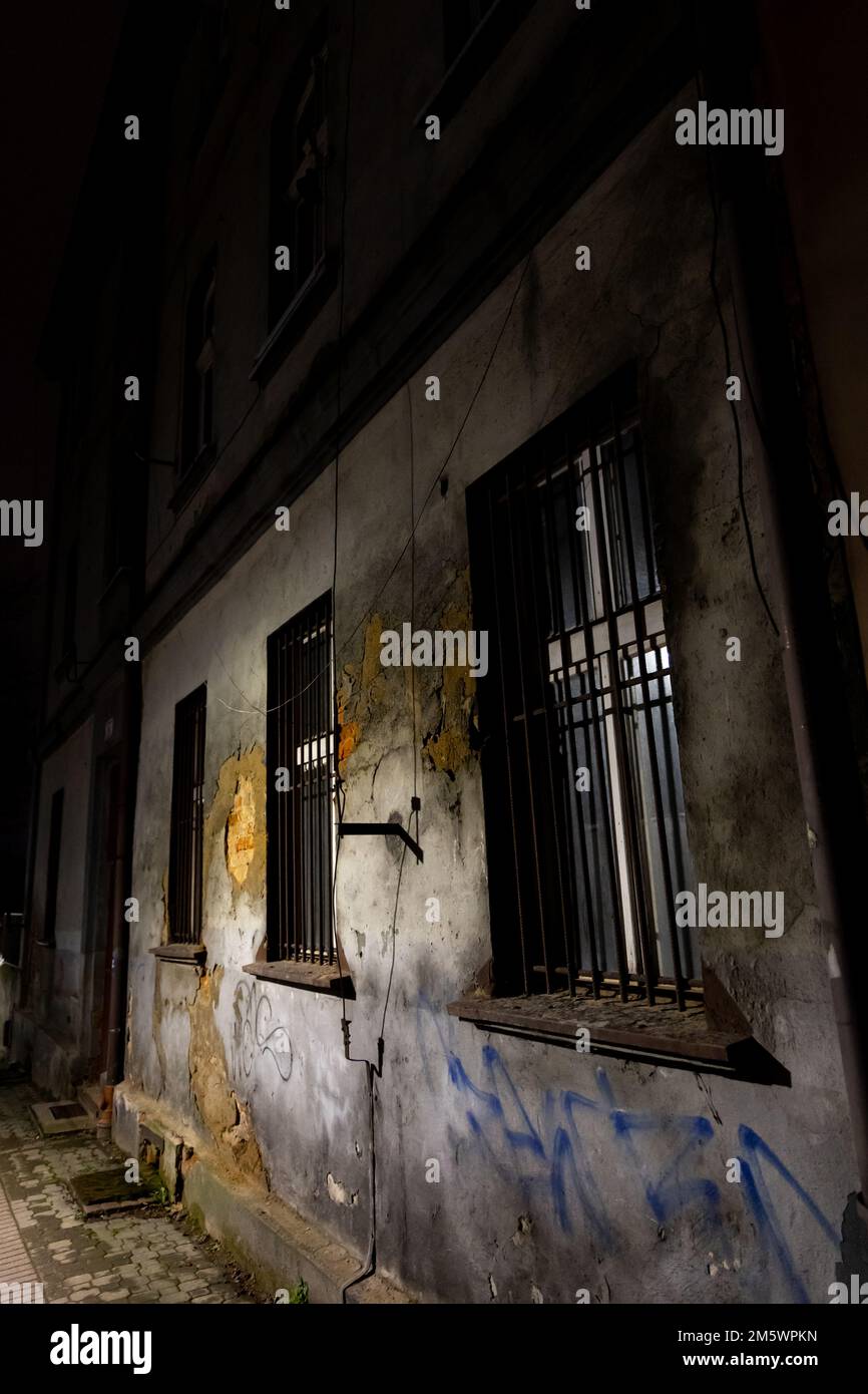 The facade of an old, abandoned tenement house. Dangerous alleys of the ...