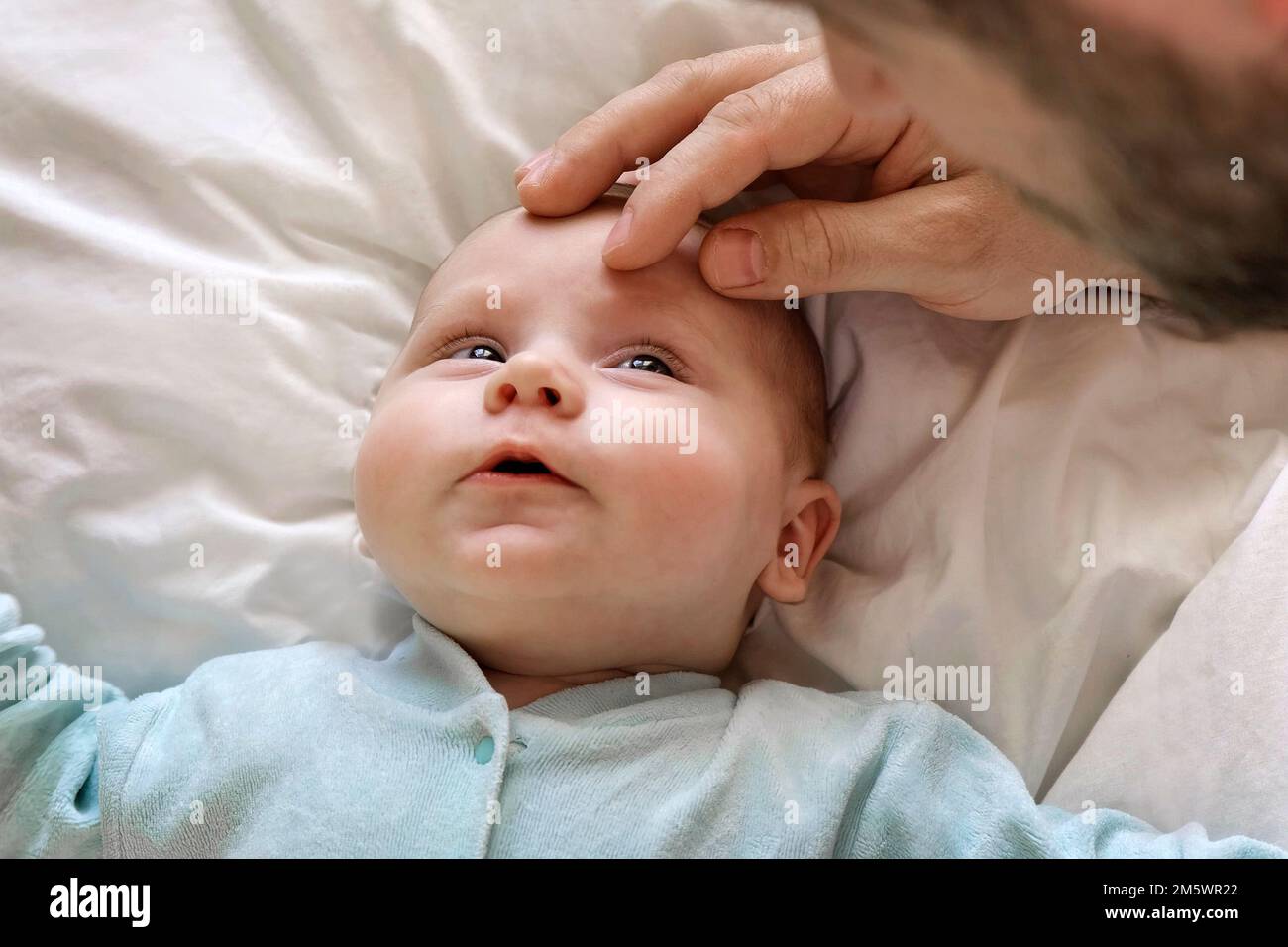 Hand caressing baby girl face hi-res stock photography and images - Alamy