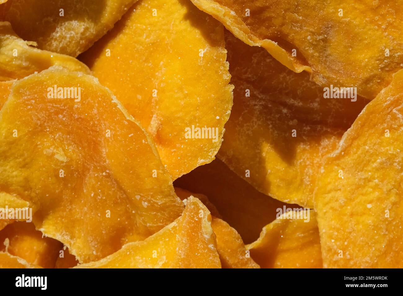 Dried mango slices close-up on a white. Top view. Closeup. Mango chips ...