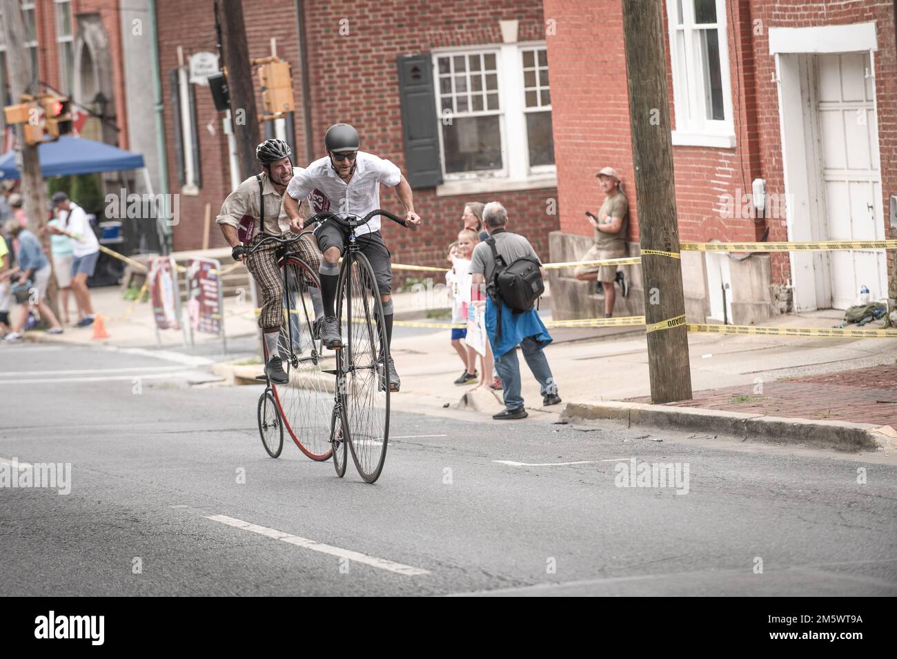 Two riders racing on their penny-farthing bicycle downtown - the ...