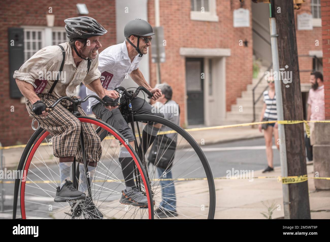 Two riders racing on their penny-farthing bicycle downtown - the ...