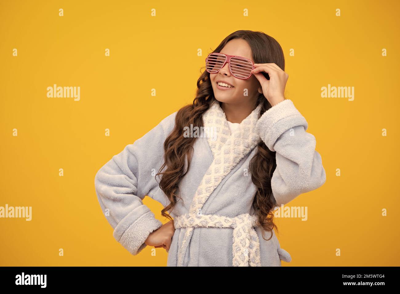 Portrait of teenage girl in funny glasses and pajama or home bathrobe ...