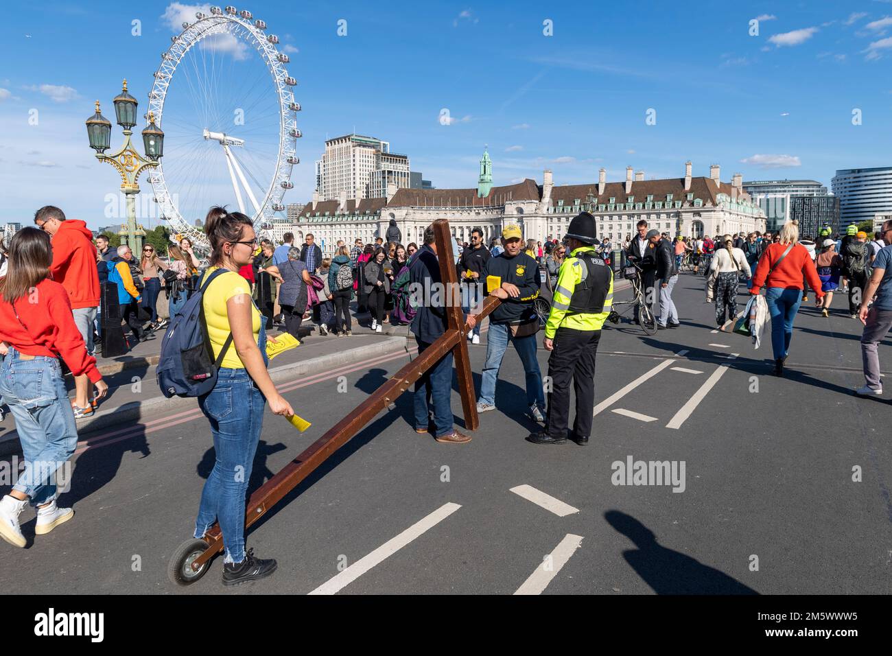 A group of christians with a large cross talking with a policeman ...