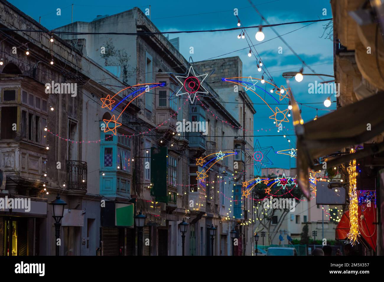Street with balcony in malta and a lot of christmas ornaments and ...