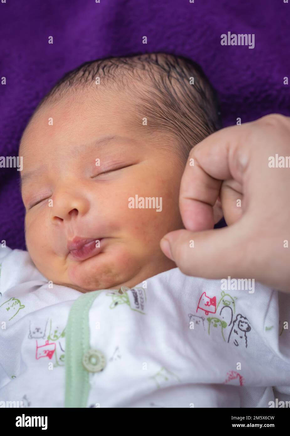 mother tapping his baby on cheek for waking up from flat angle Stock ...