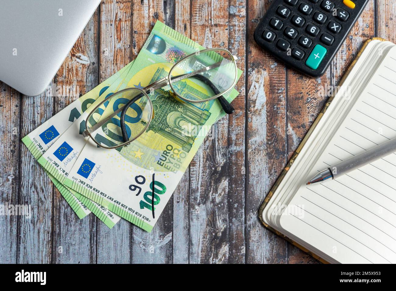 A top view of 100 euro banknotes, pen and calculator, Depreciation of ...
