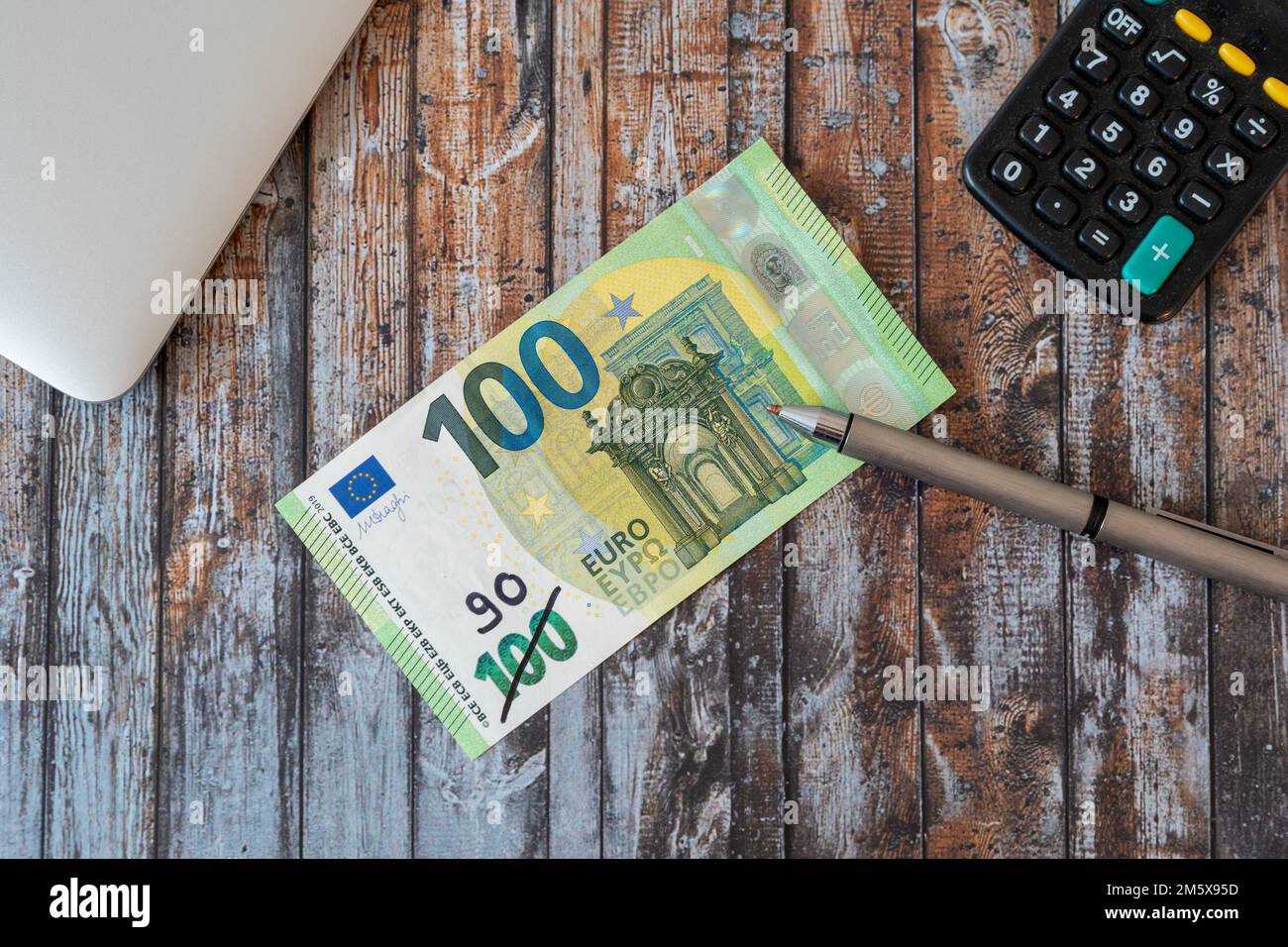 A top view of 100 euro banknote, pen and calculator, Depreciation of ...