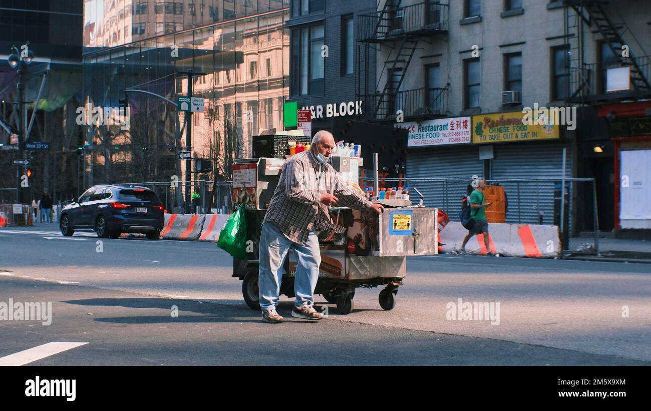 The New York City Man pushing his cart across the street Stock Photo ...