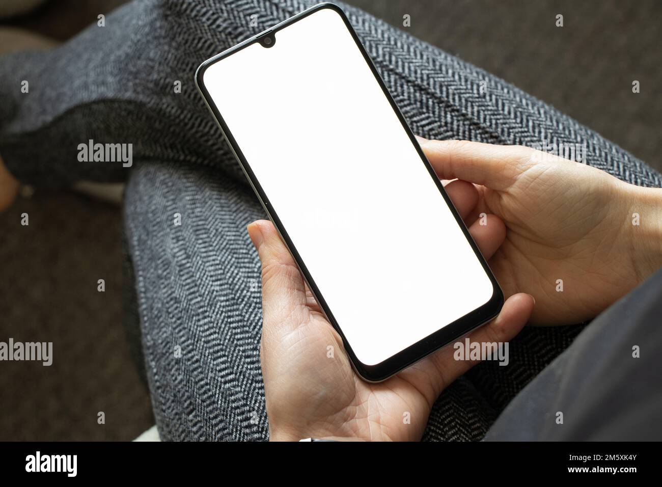 phone in the hands of a young girl with a white screen for design close ...
