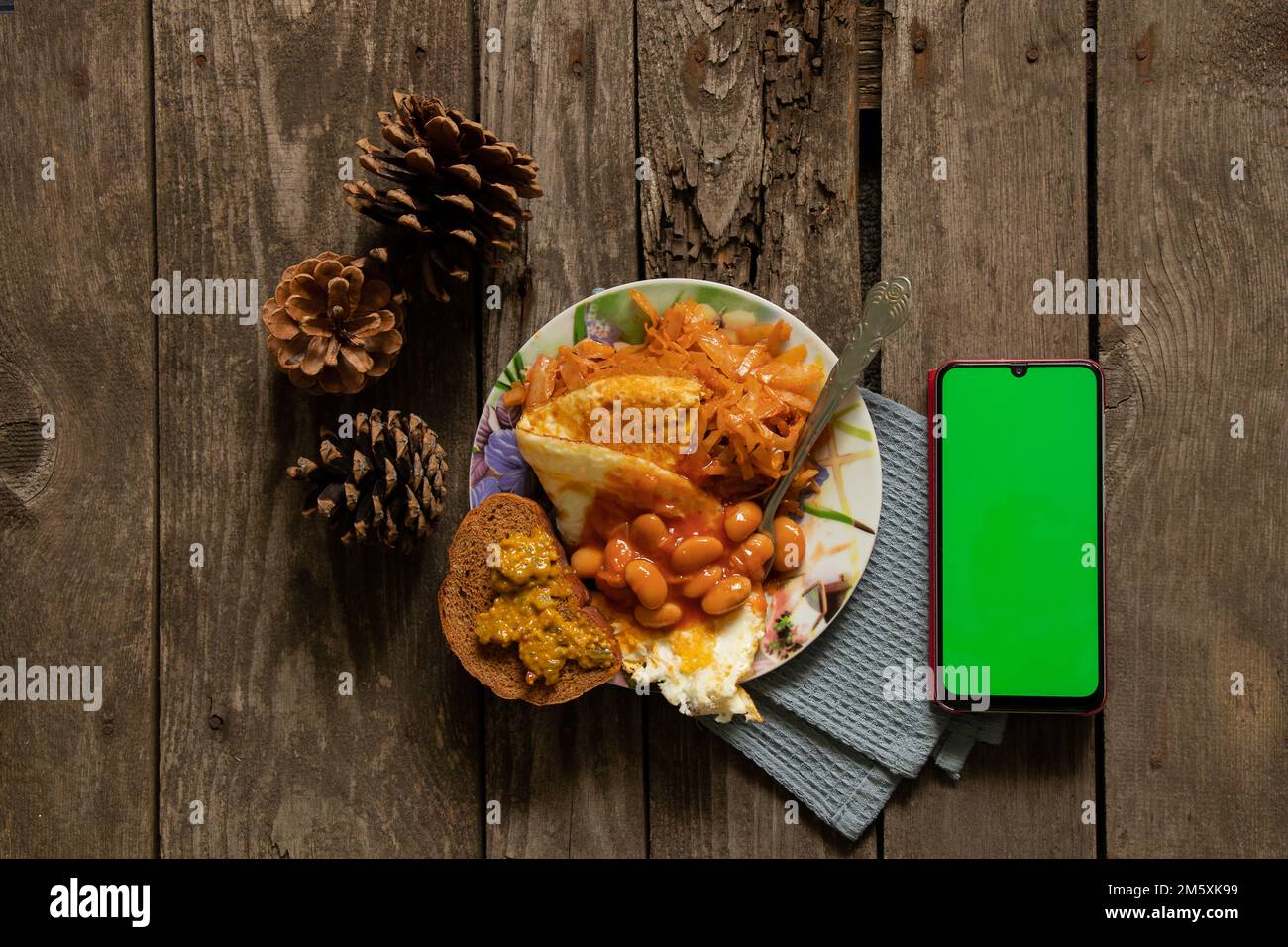 lunch plate with fried egg and salad and a phone with a green screen ...