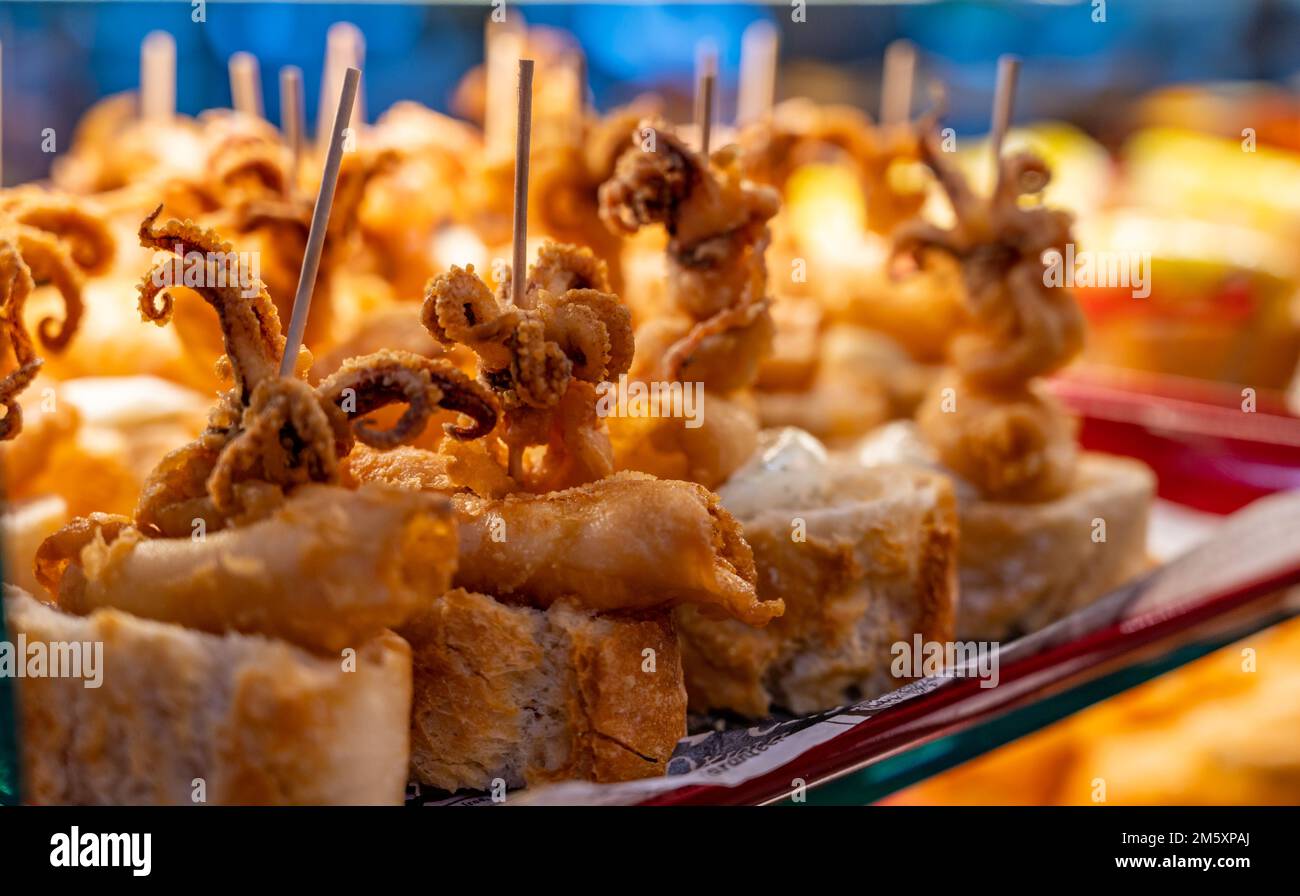 Typical snack of Basque Country, pinchos or pinxtos skewers with small ...