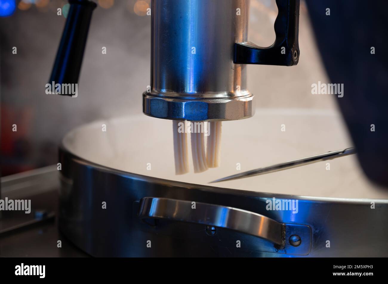 Machine for making sweet Spanish dessert churros sticks on night ...