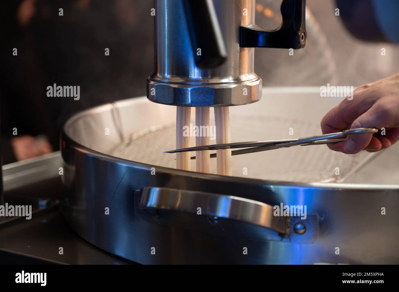 Machine for making sweet Spanish dessert churros sticks on night ...