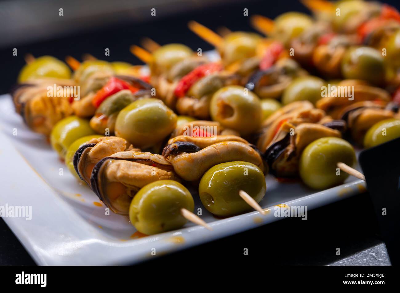 Typical snack of Basque Country, pinchos or pinxtos skewers with small ...